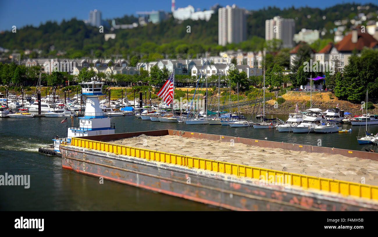A tugboat pushes a barge of sand down the Willamette River in Portland ...