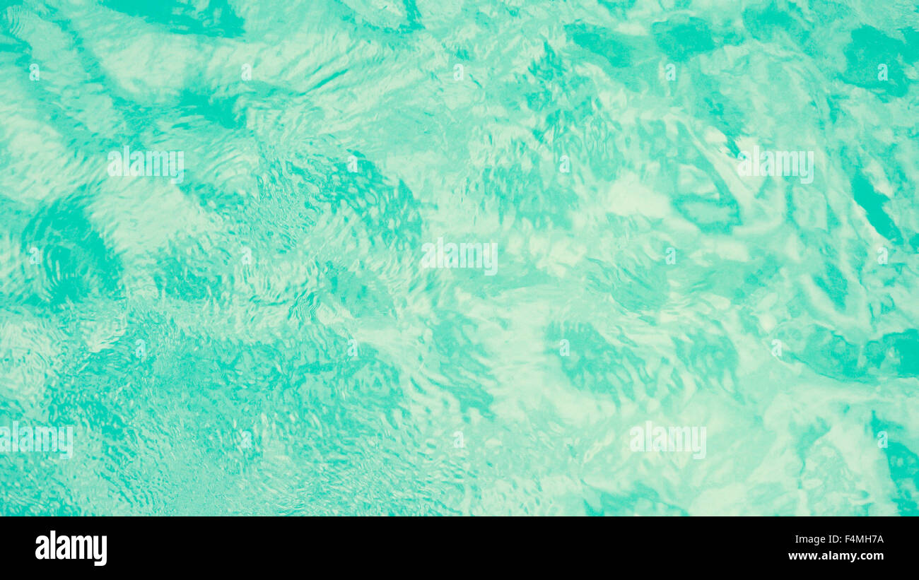 The blue surface of tropical ocean water creates an abstract pattern ...