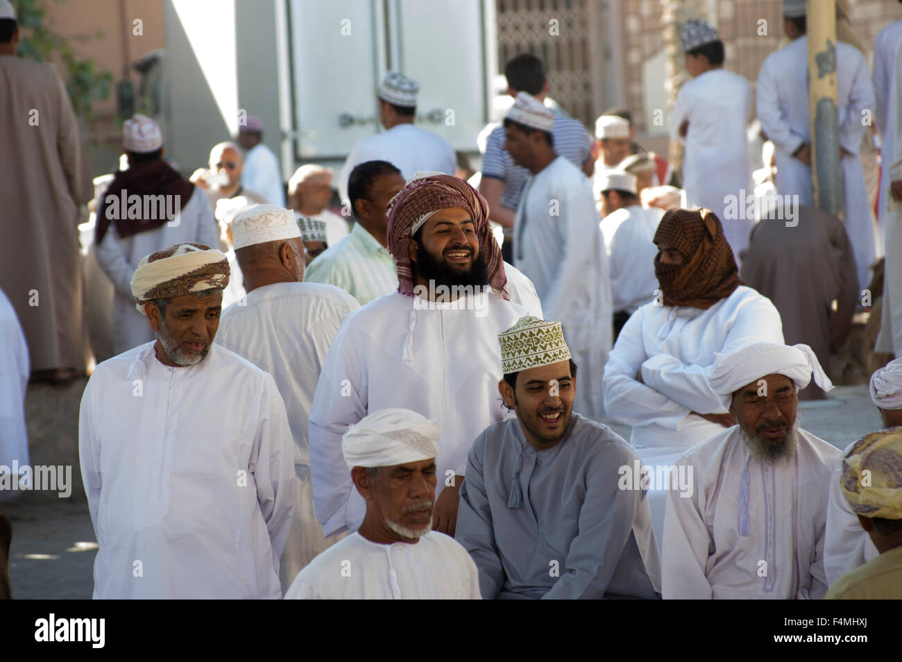 Omani men smiling and laughing watching livestock for sale at the ...