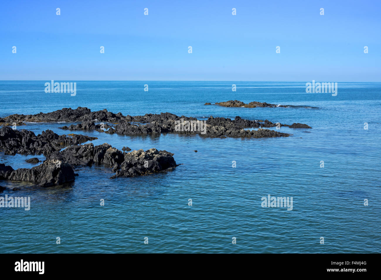 A rock reef between two sandy beeches. Popular with tourists Stock ...