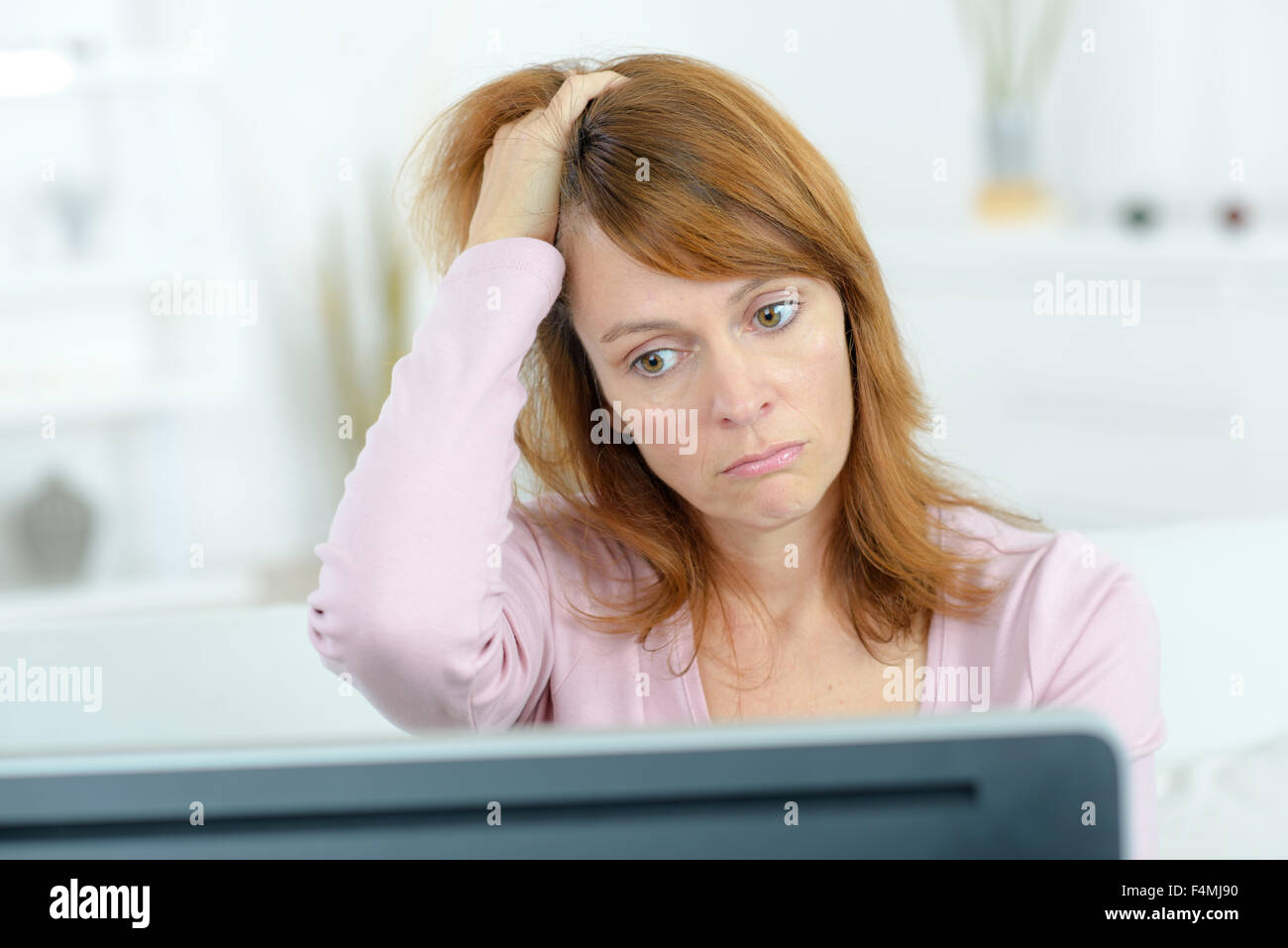 Stressed woman looking at her computer screen Stock Photo - Alamy