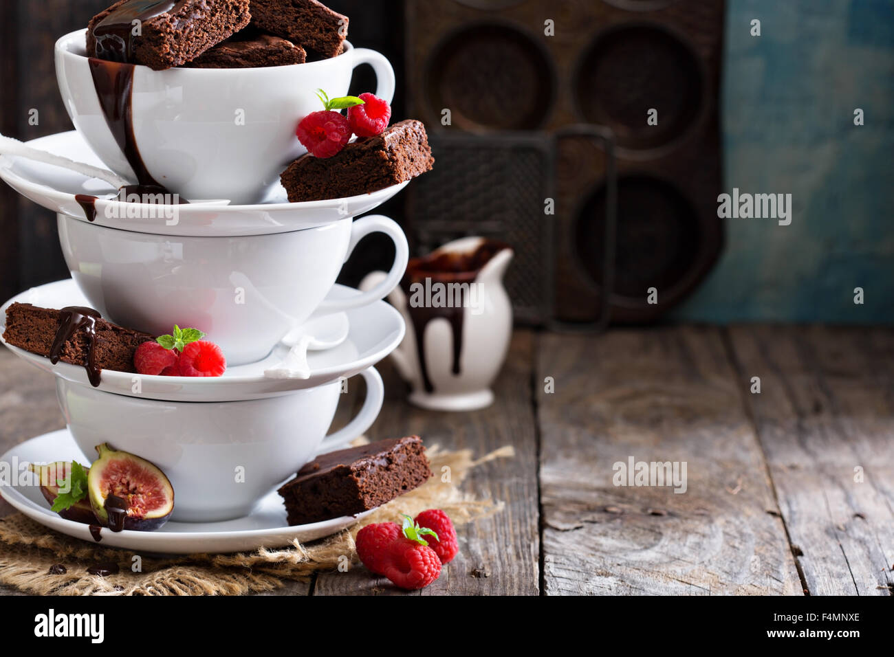 Brownies in stacked coffee cups with hot fudge chocolate sauce Stock ...