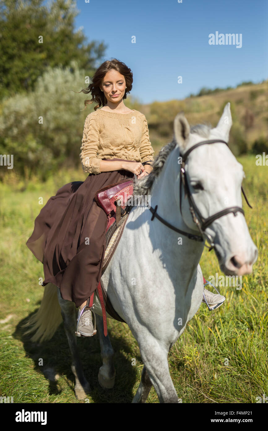Beautiful girl riding a white horse Stock Photo - Alamy