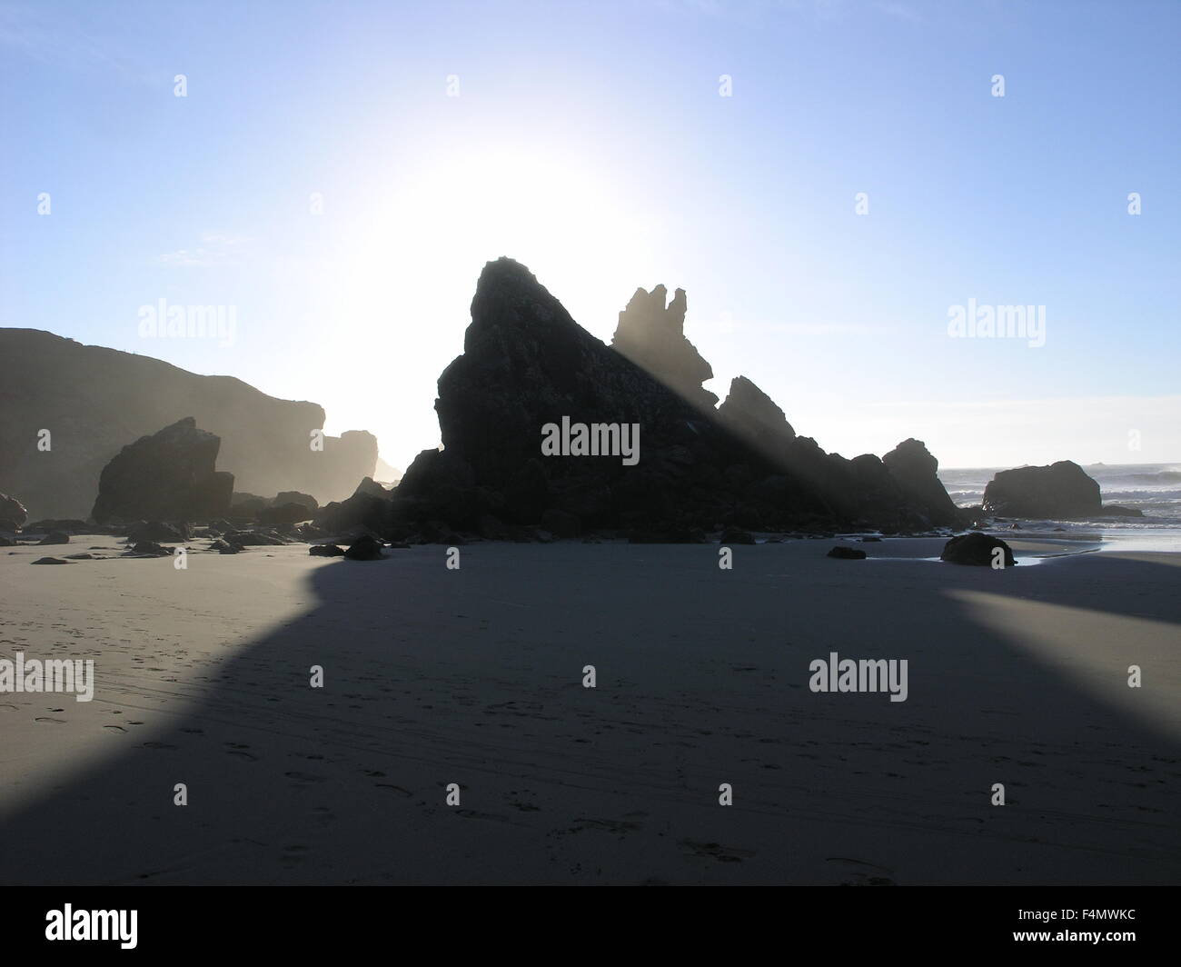 Rock forming shadow on beach Stock Photo - Alamy