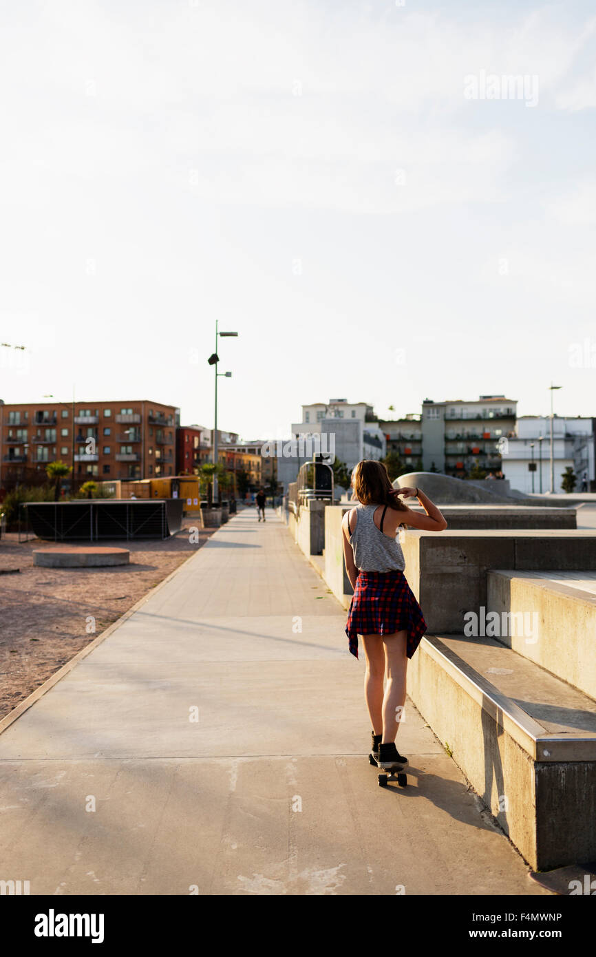Full length rear view of teenage girl skateboarding in skate park Stock ...