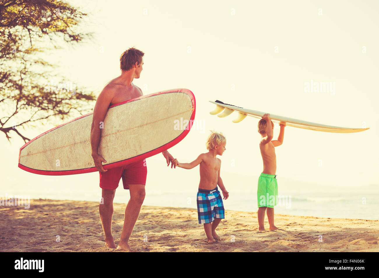Father and sons going surfing together. Summer fun outdoor lifestyle ...