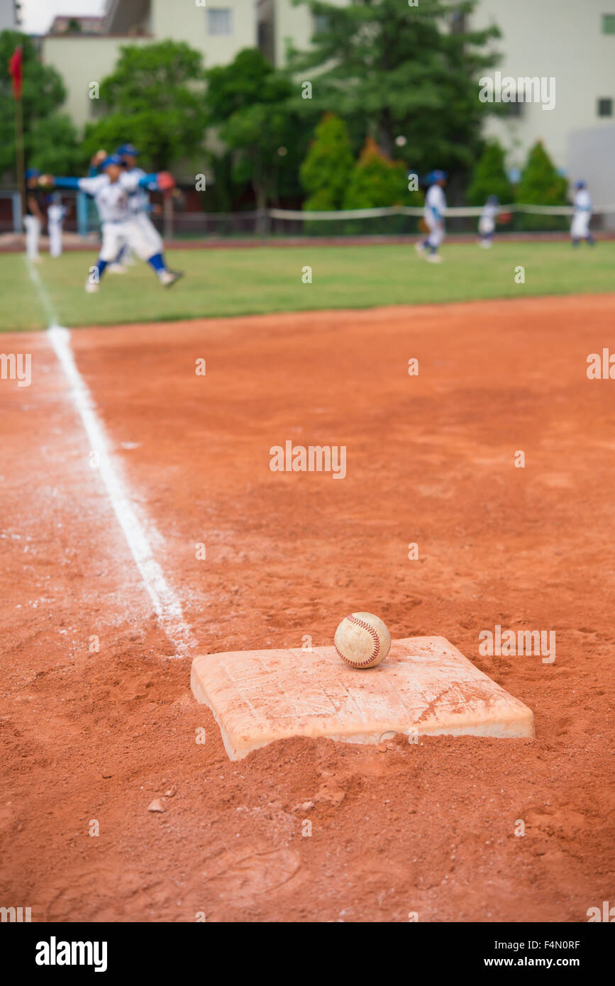 baseball and base on baseball field with players on background Stock ...