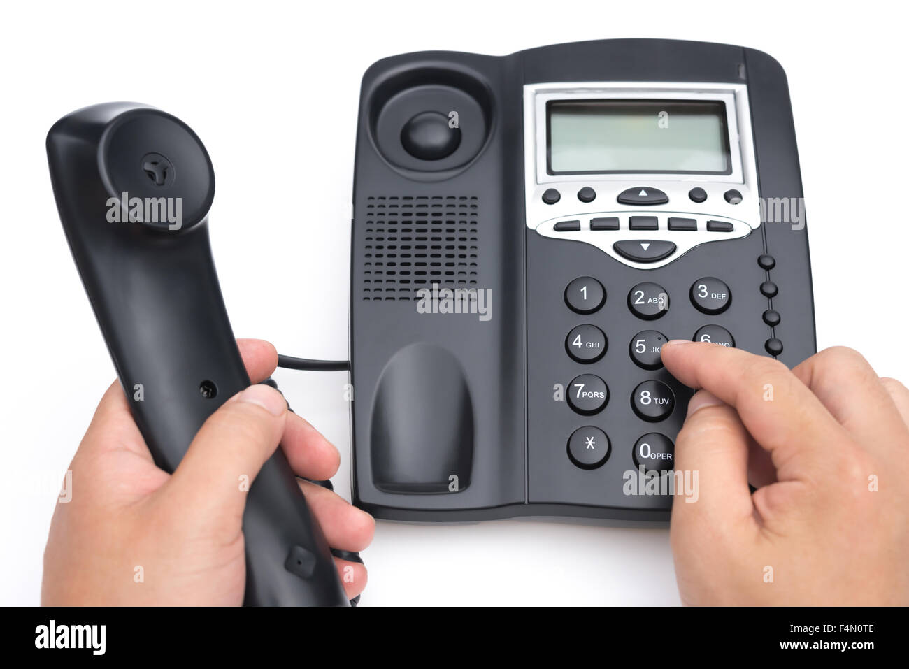 man dialing a black telephone on a white background Stock Photo - Alamy