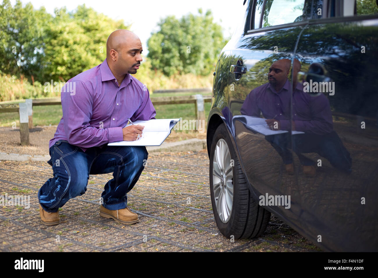 man inspecting the side of a car Stock Photo - Alamy