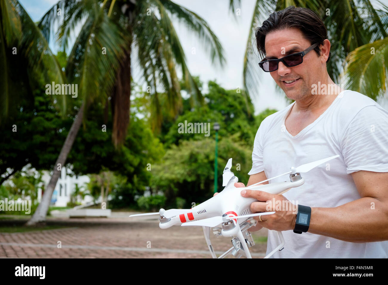 Portrait of man with smartwatch holding drone with camera Stock Photo ...