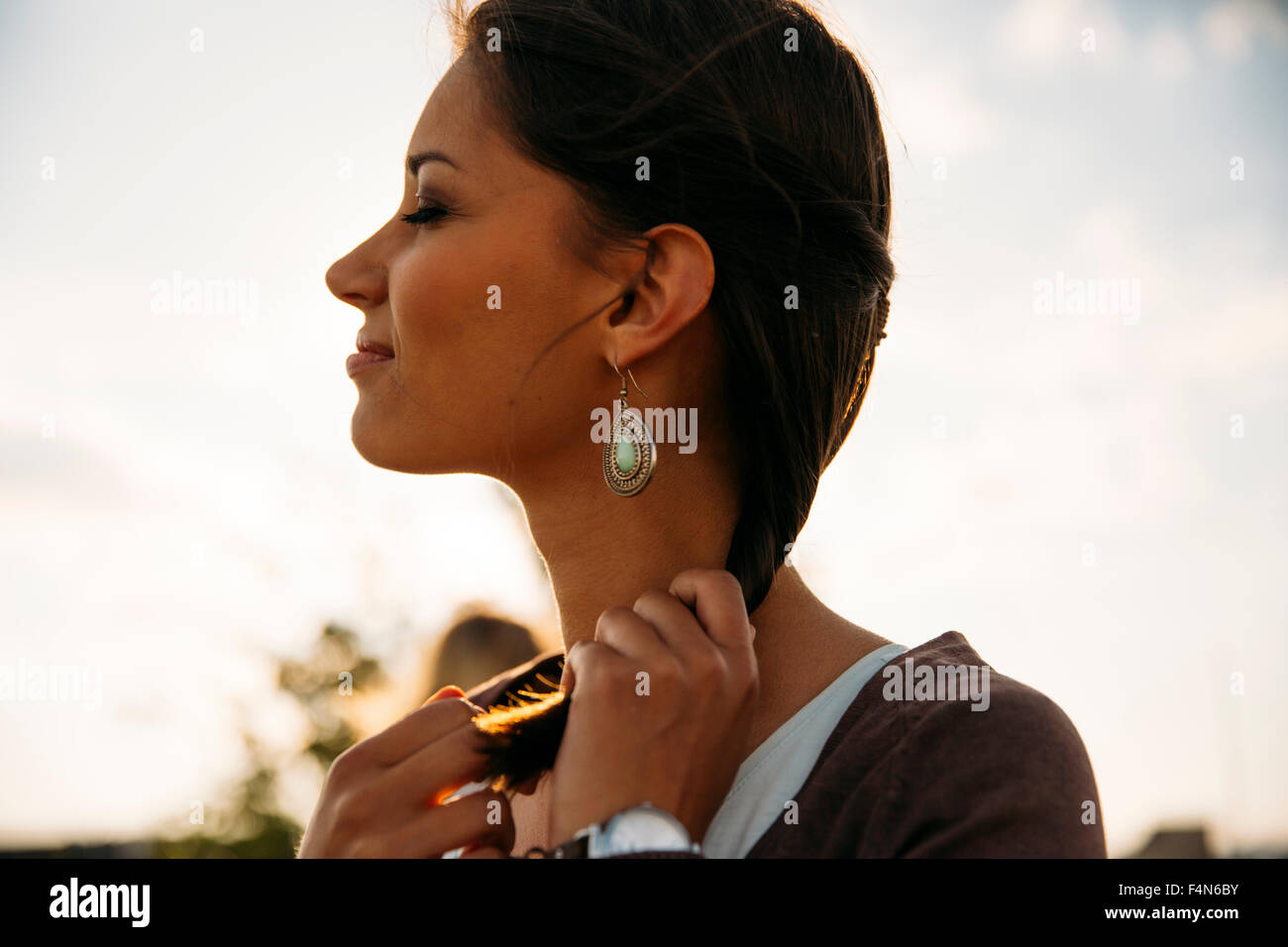 Profile of smiling young woman at backlight Stock Photo - Alamy