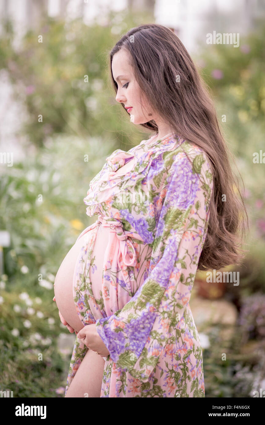 Pregnant Woman Wearing Fashionable Bathrobe Holding Her Belly Stock