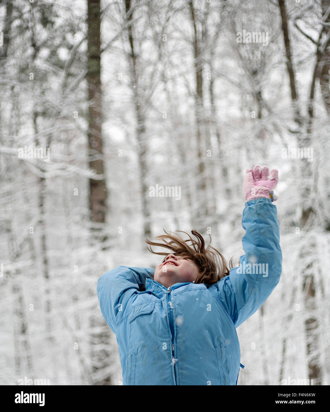 Girl throwing snow in the woods Stock Photo - Alamy