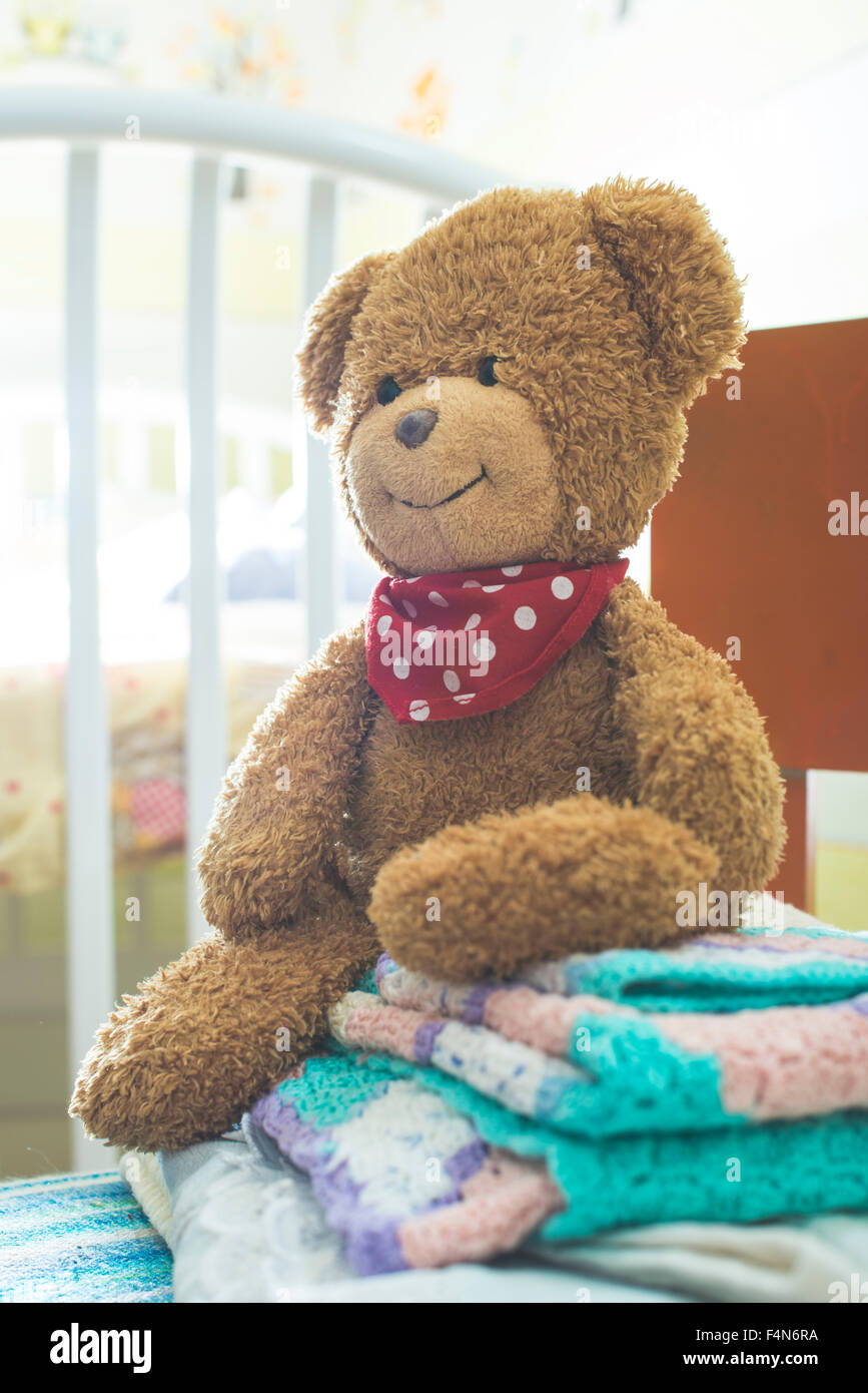 Stack of blankets and a teddy-bear on a chair Stock Photo - Alamy