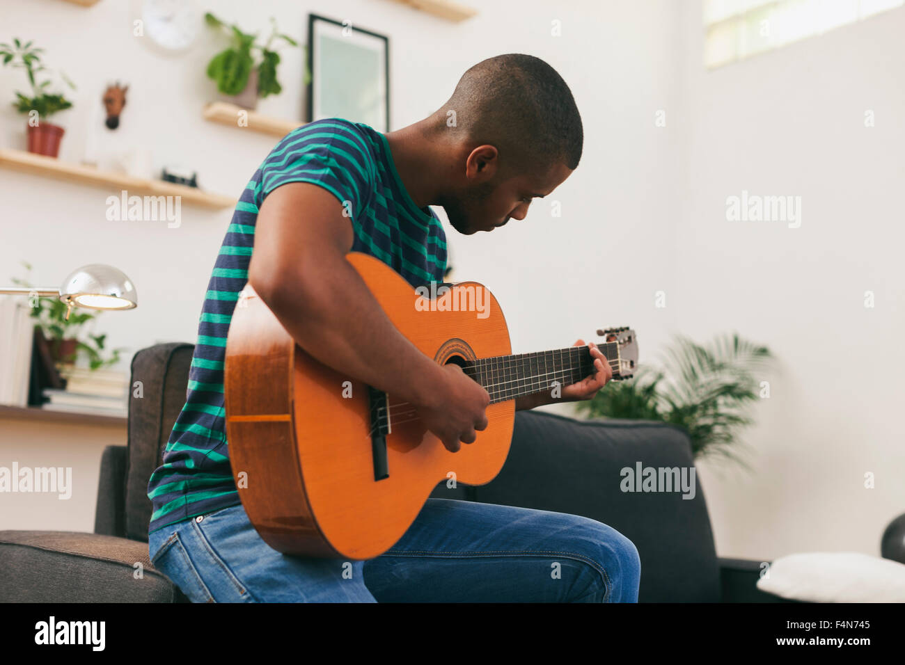 Man playing guitar at home Stock Photo - Alamy