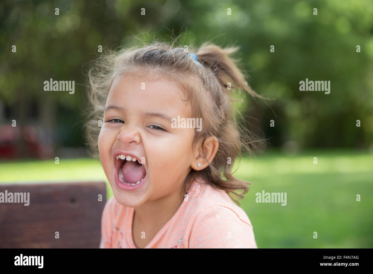 Portrait of screaming little girl in a park Stock Photo - Alamy