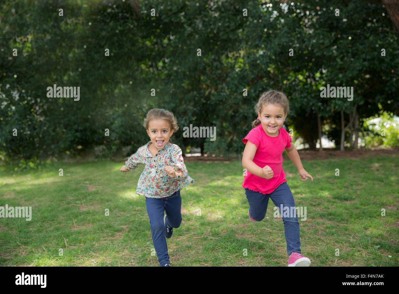 Two girls running in a park Stock Photo - Alamy