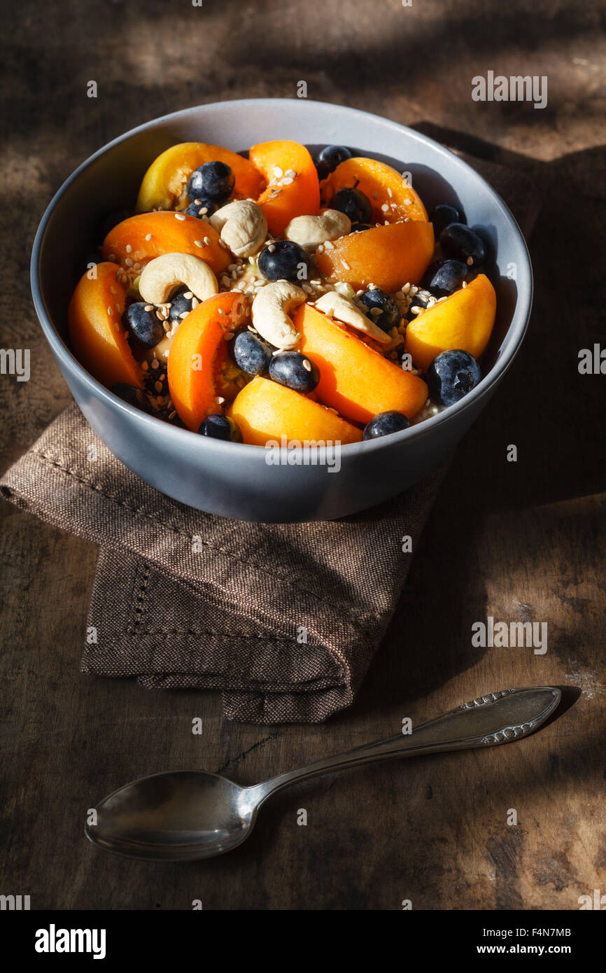 Bowl of muesli with cracked buckwheat, fruits, sesame and cashew nuts ...
