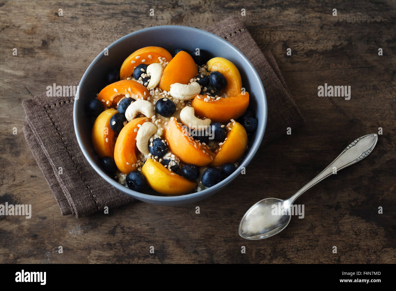 Bowl of muesli with cracked buckwheat, fruits, sesame and cashew nuts ...