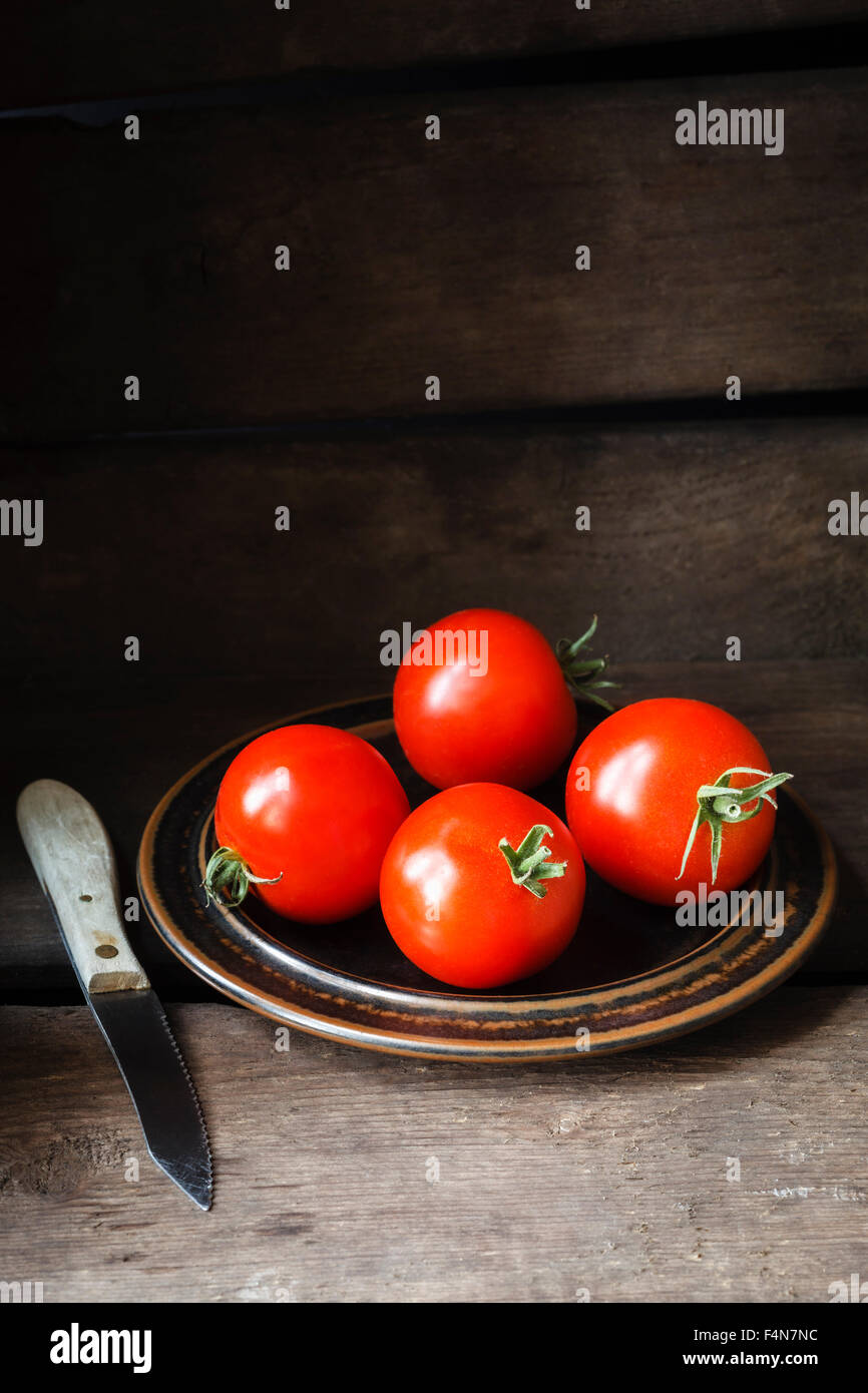 Red tomatoes, Devotion, on plate, kitchen knife Stock Photo - Alamy