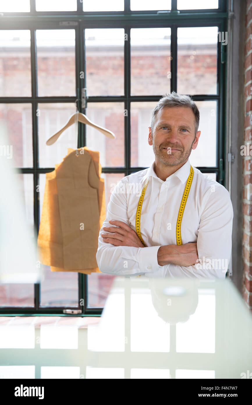 Mature tailor standing in his shop Stock Photo - Alamy