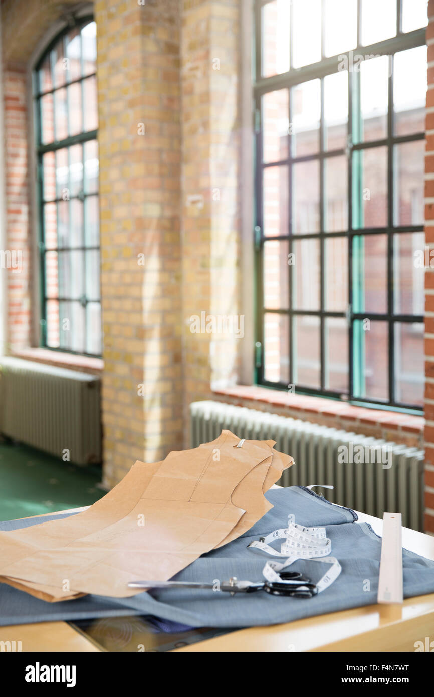Germany, Berlin, Cut pattern and fabric on table at men's tailor Stock ...