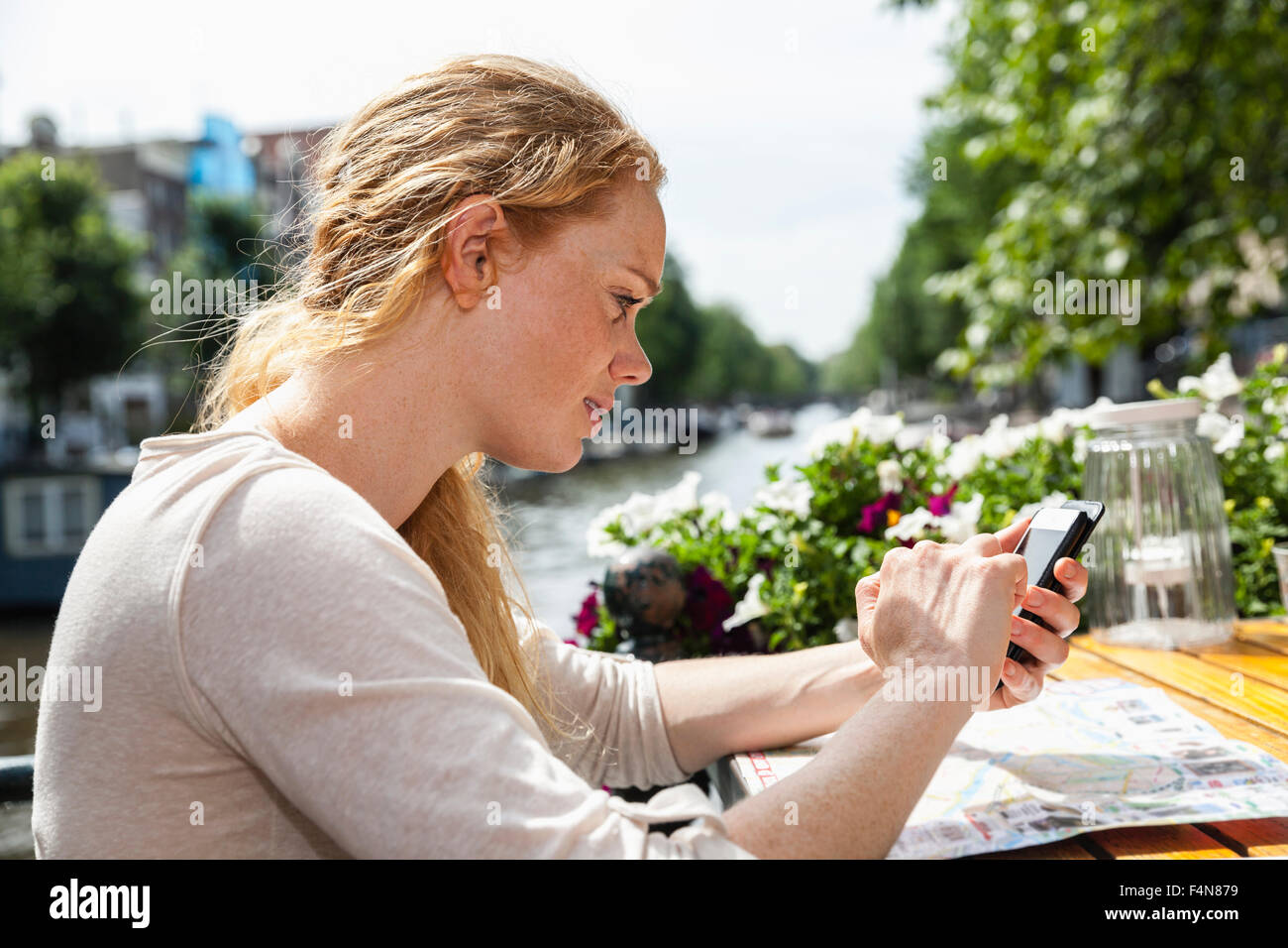 Netherlands, Amsterdam, woman with cell phone at outdoor cafe Stock ...