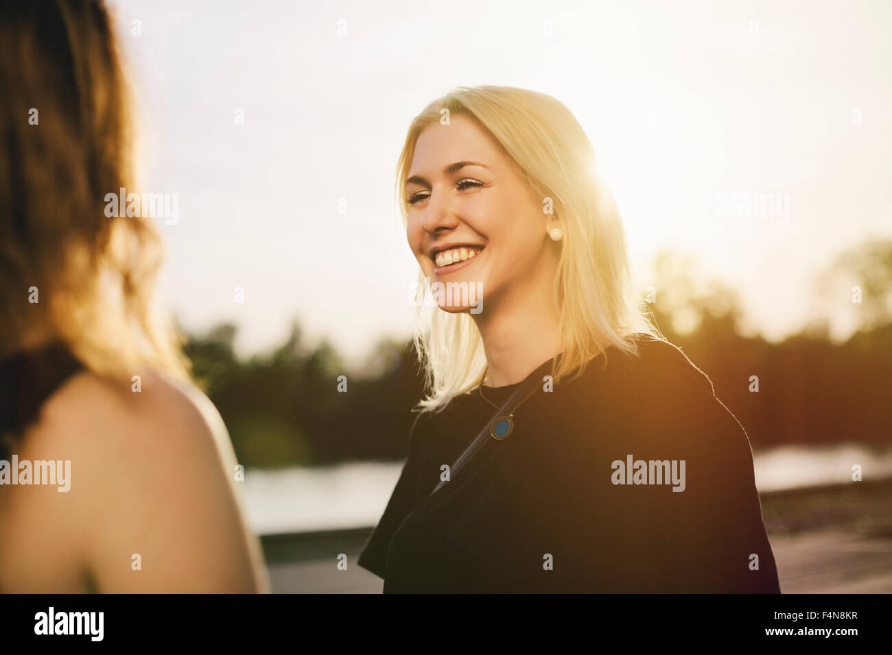 Smiling blond woman looking at her friend Stock Photo - Alamy