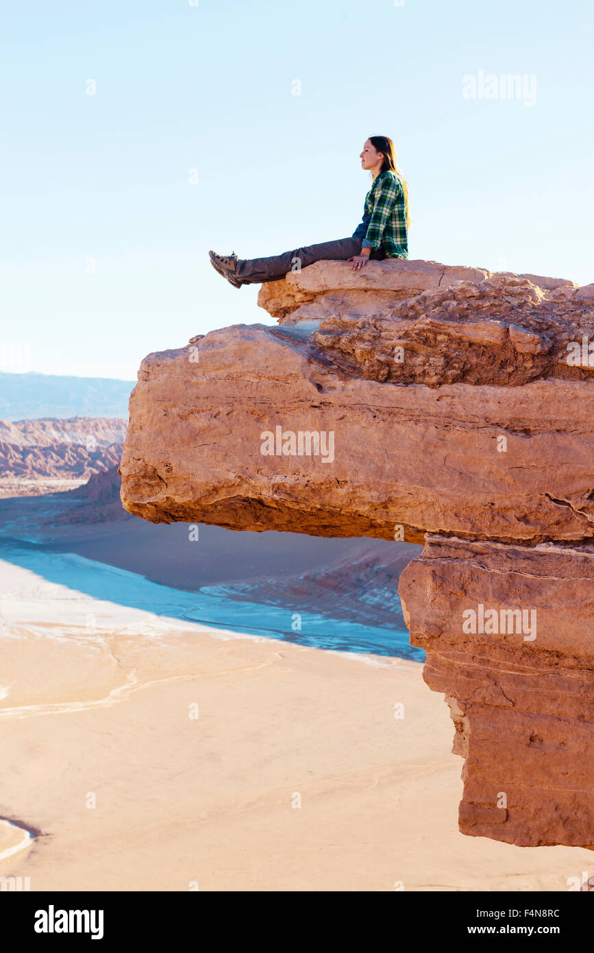 Chile, Atacama Desert, woman sitting on a cliff looking at view Stock ...
