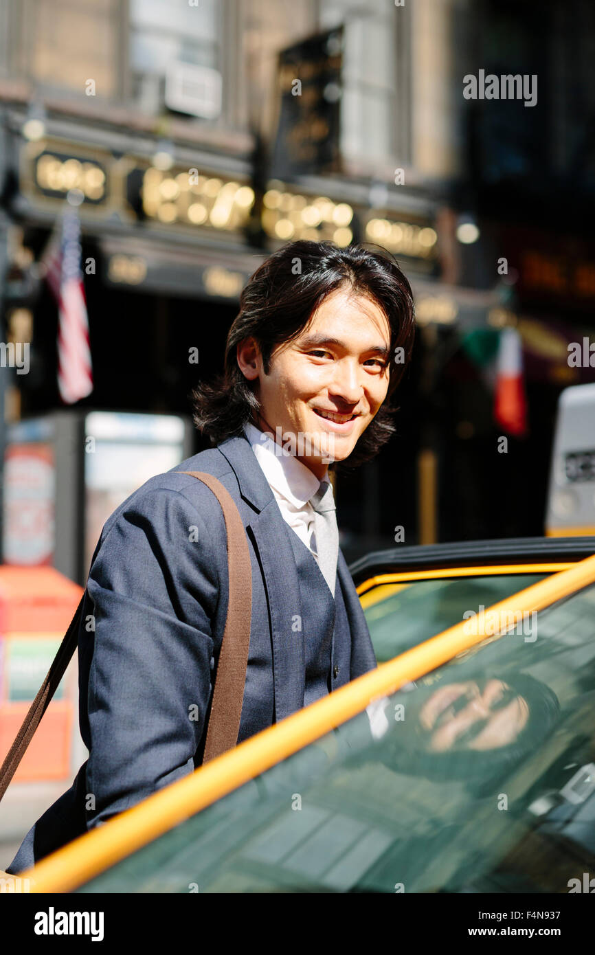 USA, New York City, smiling businessman entering a taxi Stock Photo - Alamy