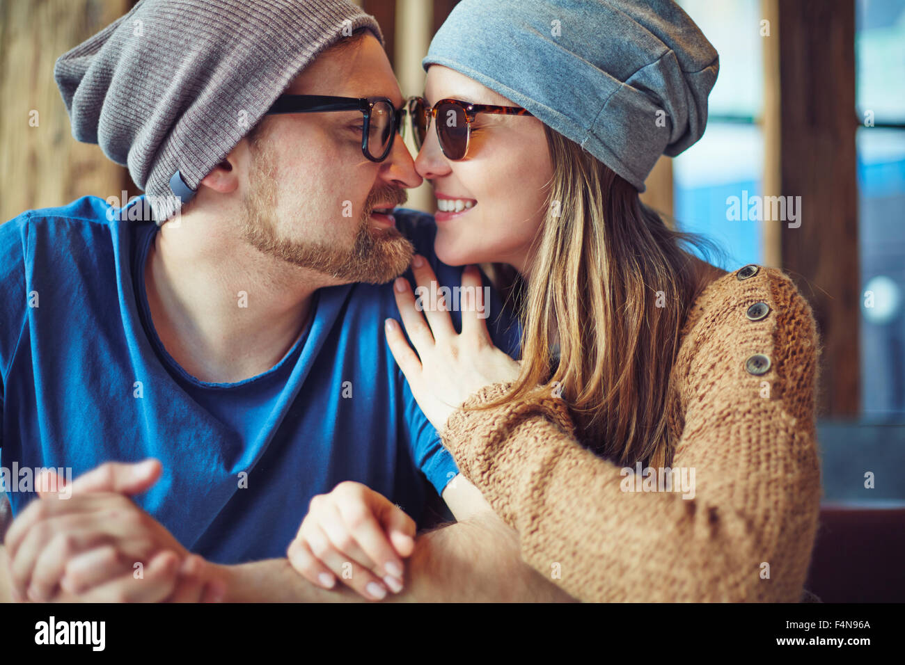 Flirty dates sitting face to face and touching by their noses Stock ...