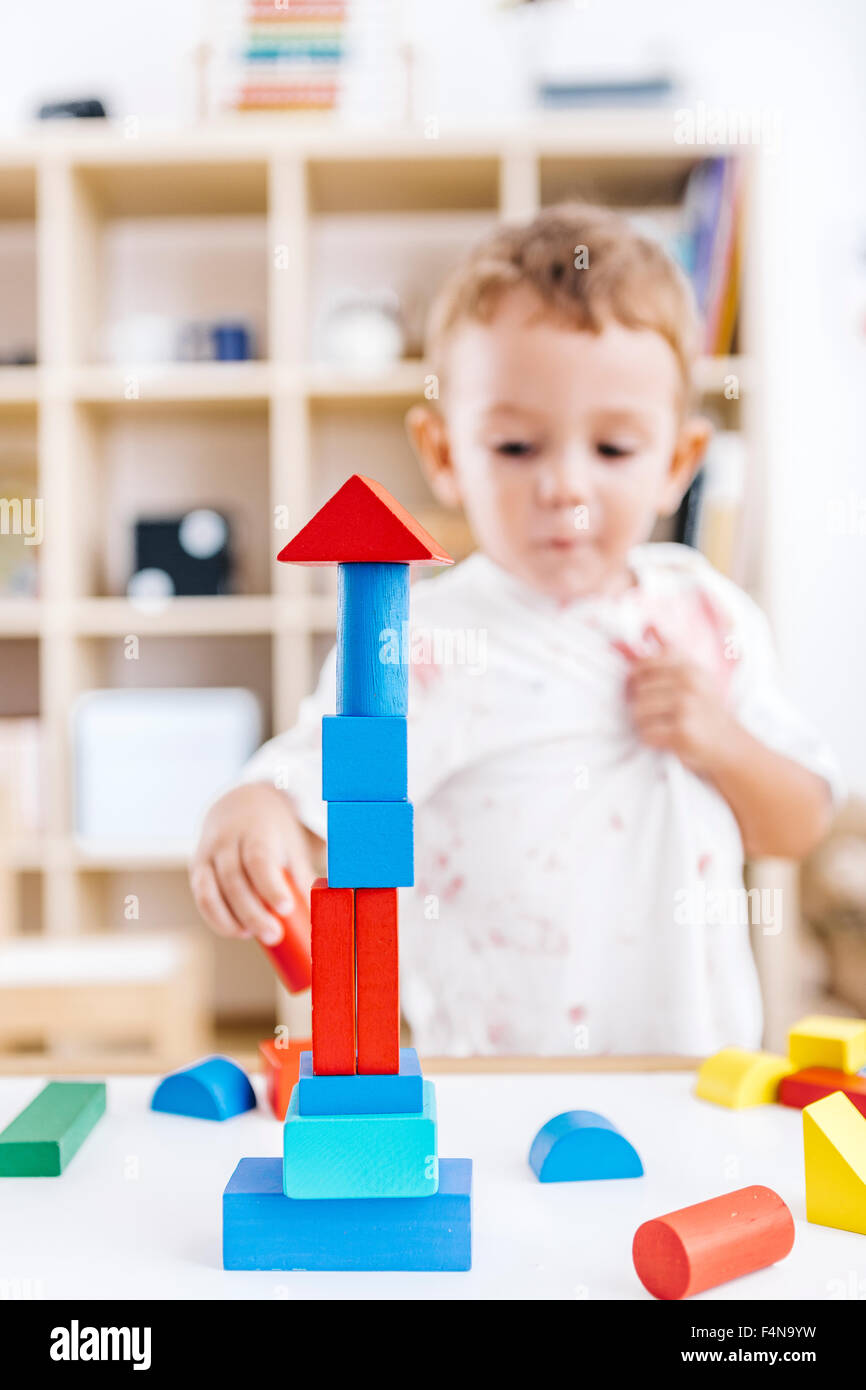 Little boy built a tower with blue and red building bricks Stock Photo ...