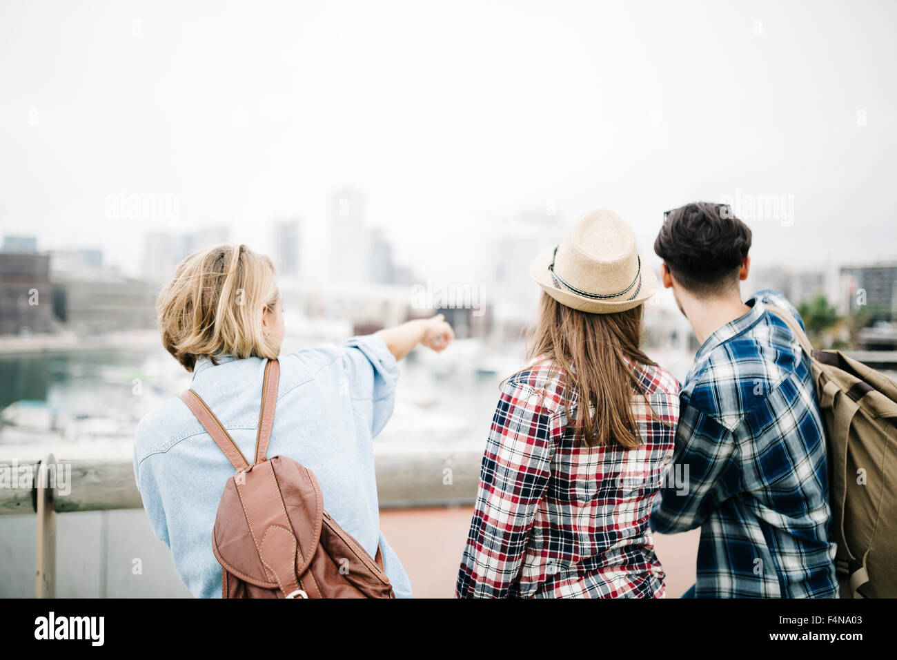Spain, Barcelona, back view of three friends standing side by side ...
