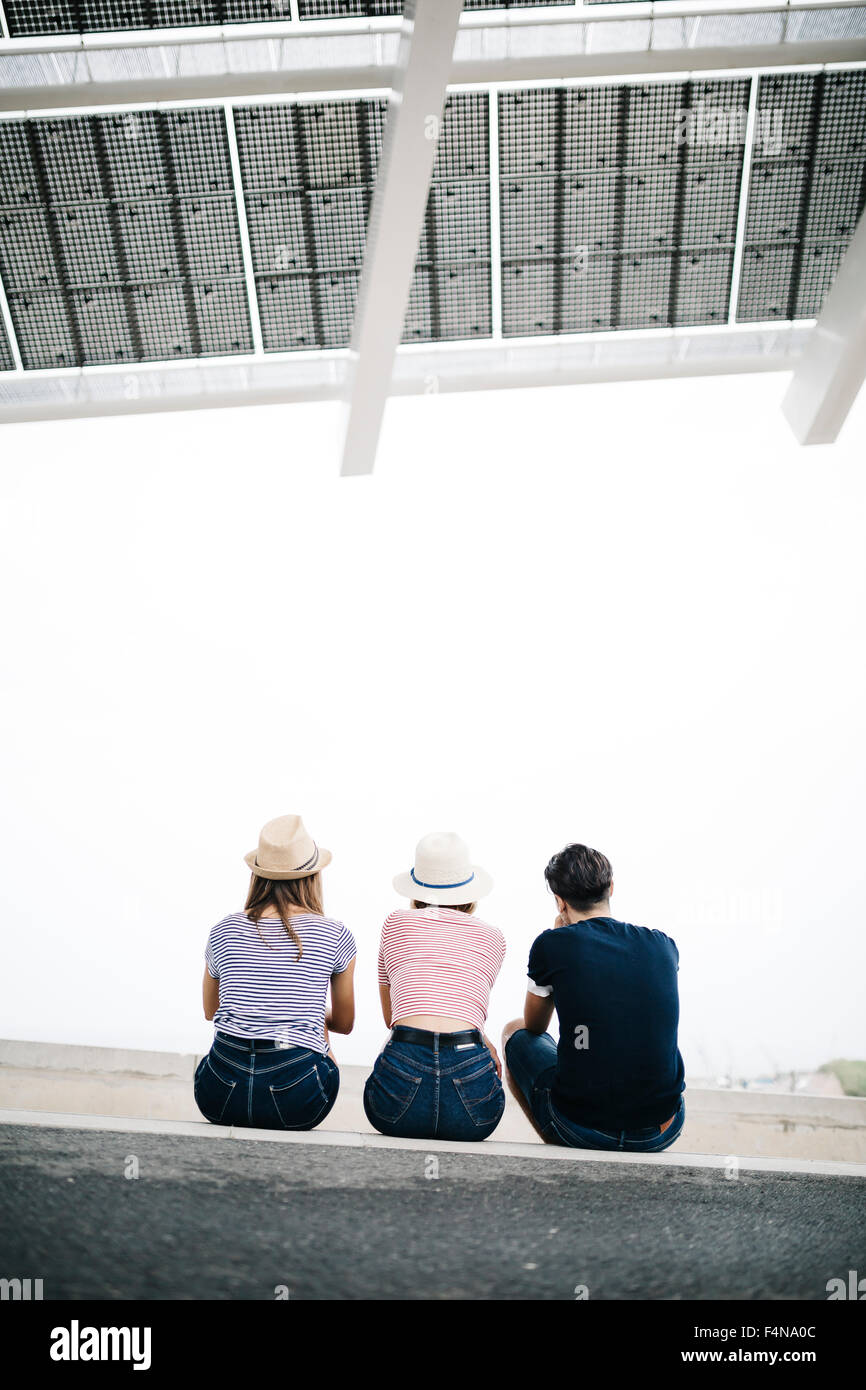 Back view of three friends sitting side by side on a step Stock Photo ...