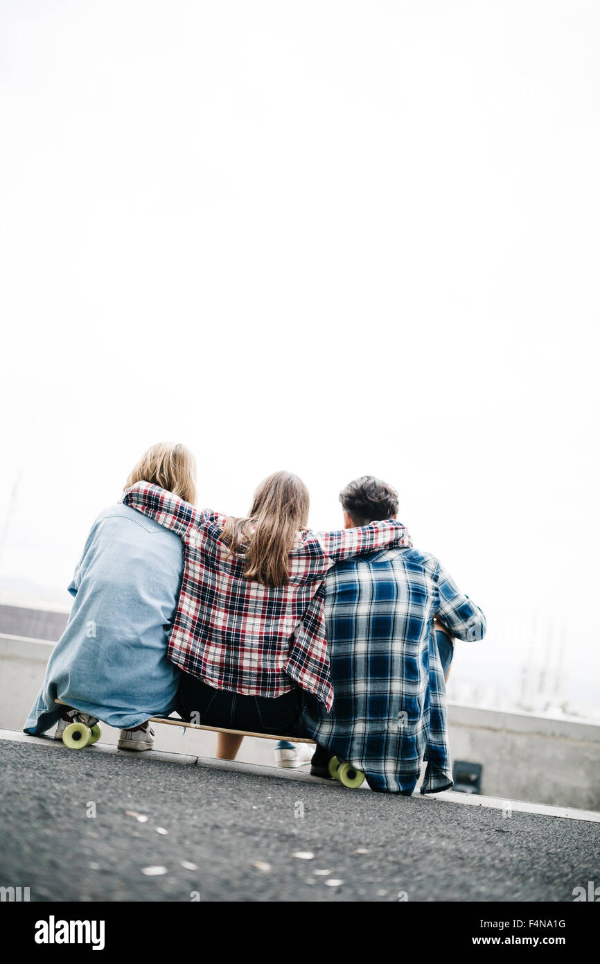 Three friends longboarding in the city Stock Photo - Alamy