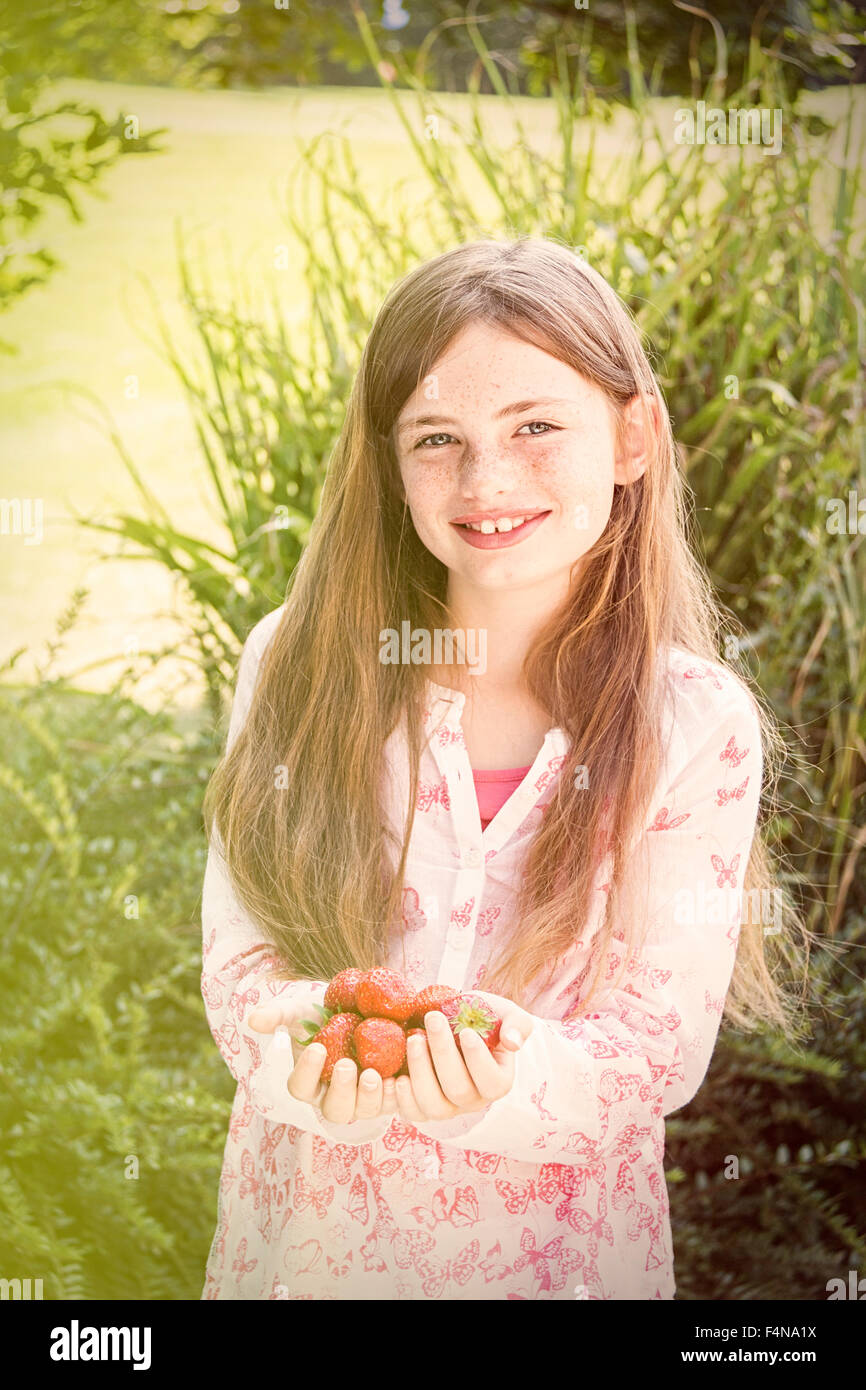 Portrait of smiling girl with handful of strawberries Stock Photo - Alamy