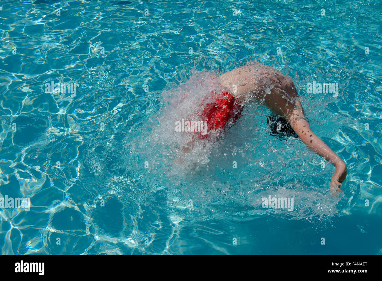 Teenage boy jumping and playing in swimming pool Stock Photo - Alamy
