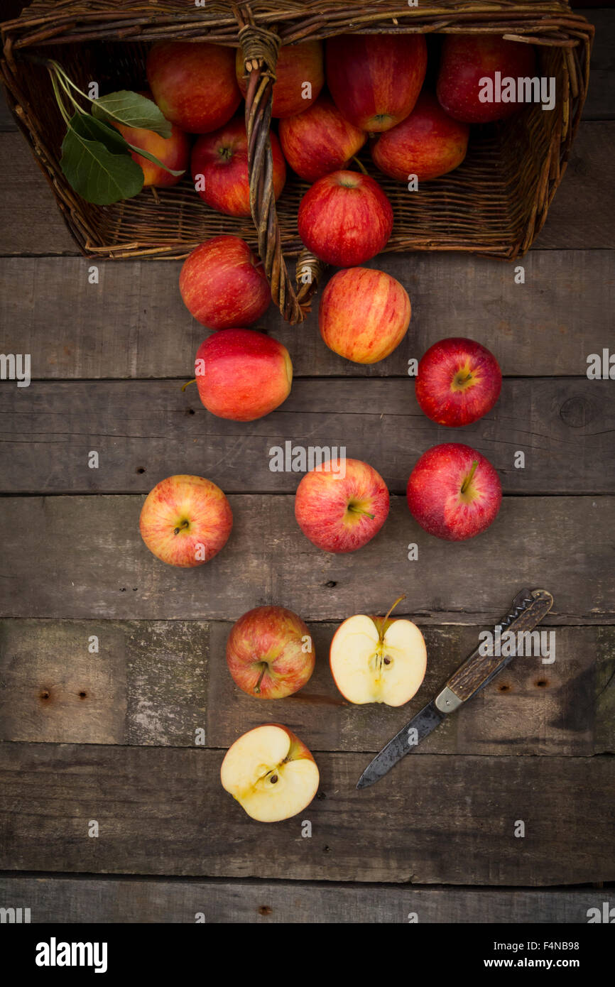 Red apples, sort Gala, basket and pocket knife on wood Stock Photo - Alamy