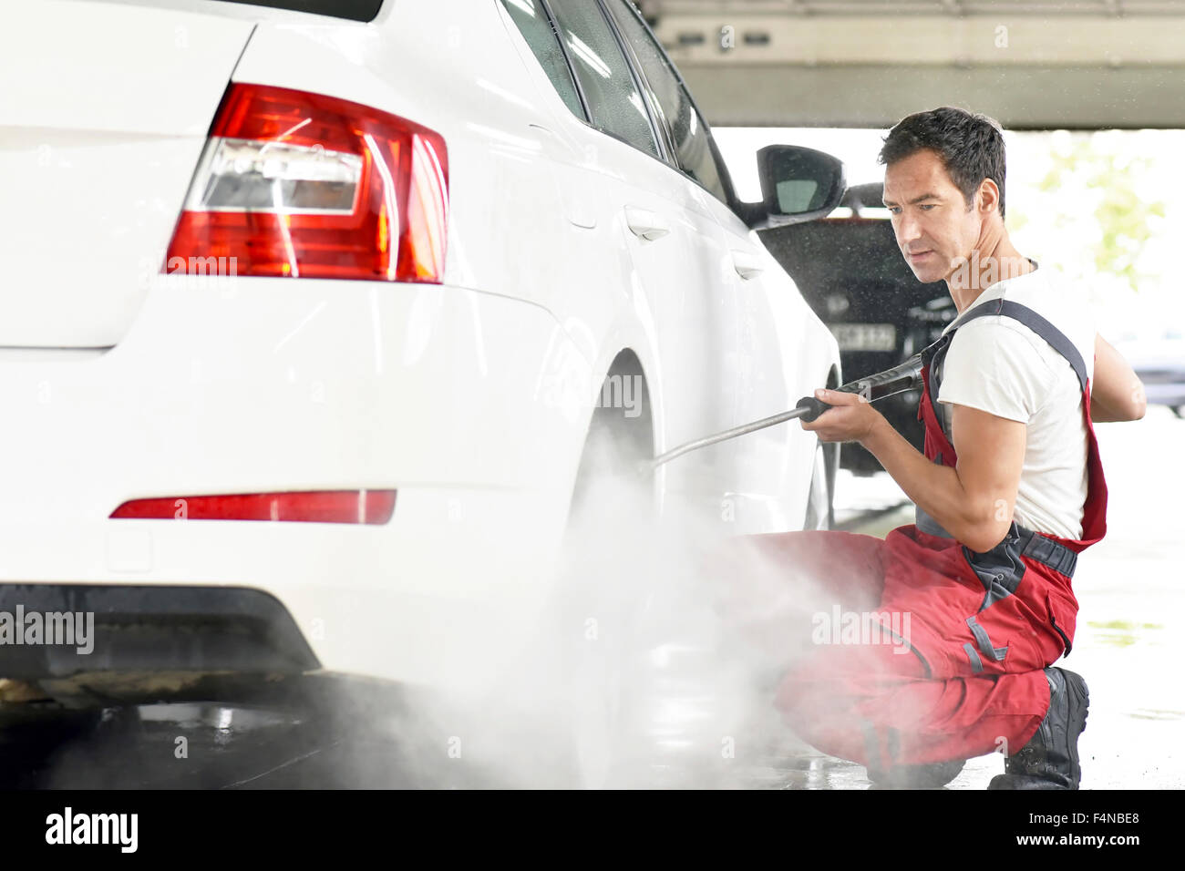 Car cleaning, man cleaning car with high-pressure cleaner Stock Photo ...