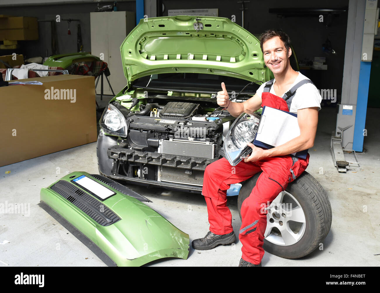 Car mechanic examining accident damaged car before repair Stock Photo ...