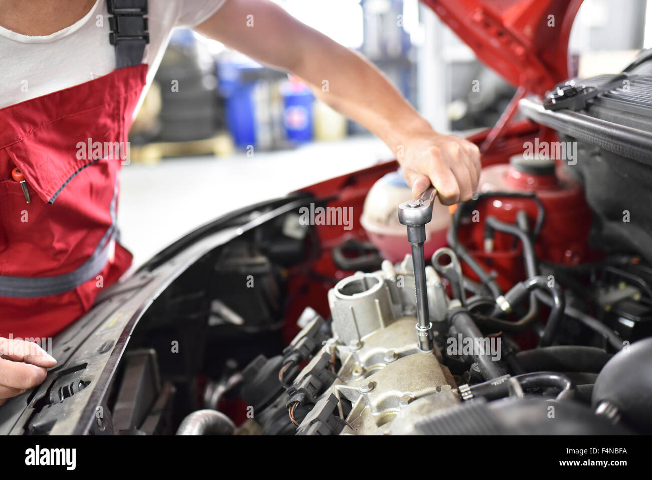 Car mechanic working in repair garage, dismantling cylinder head Stock ...