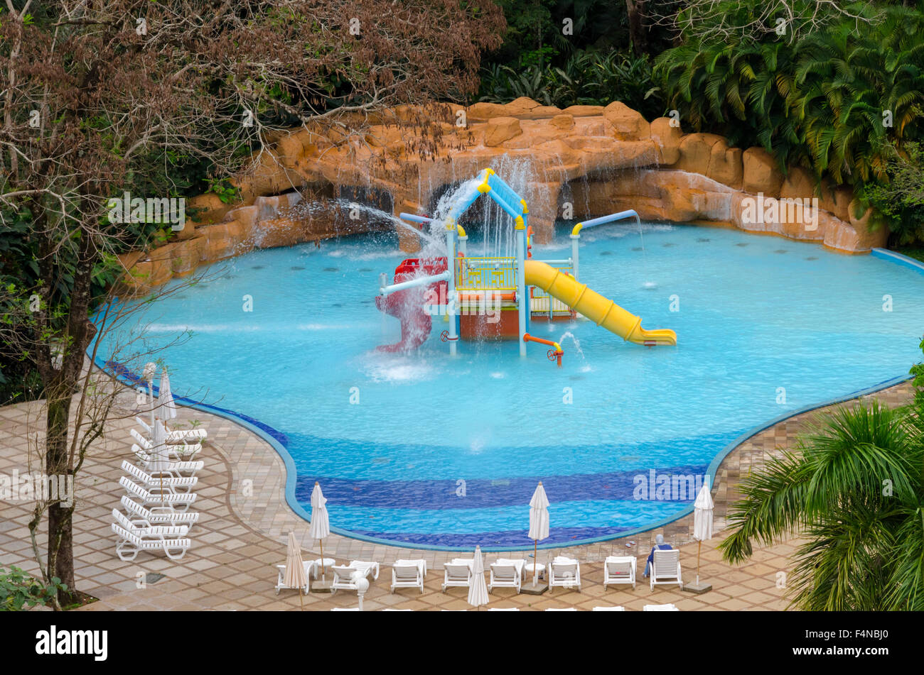 round pool with slide and fountains in the center Stock Photo - Alamy