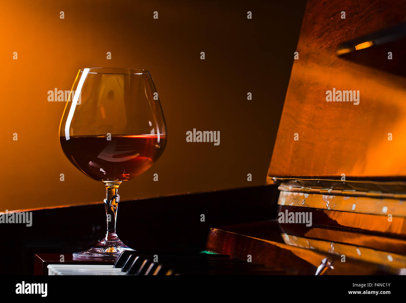 snifter with brandy on a old piano Stock Photo - Alamy