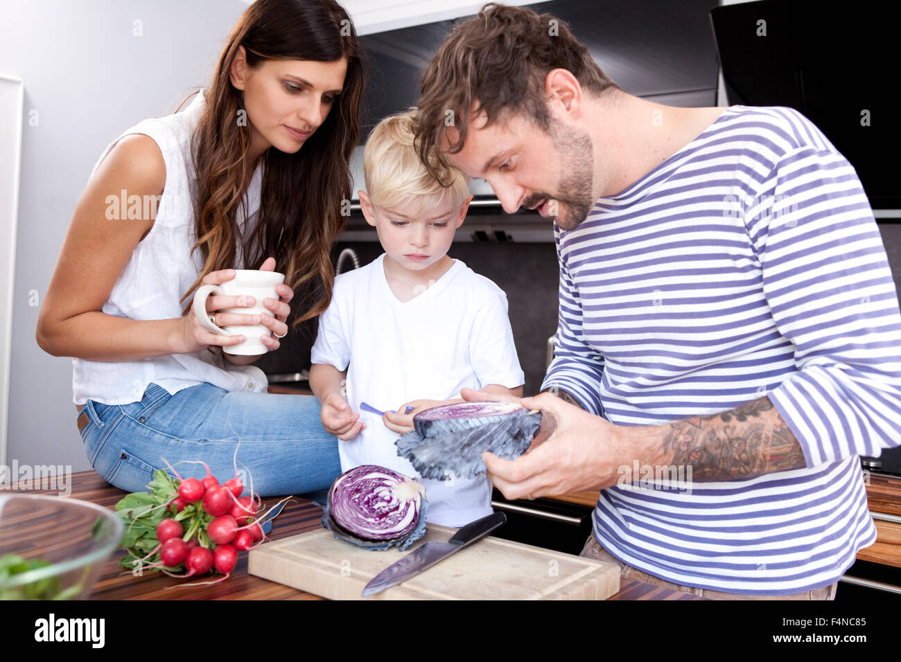 Man showing his little son red cabbage in the kitchen Stock Photo - Alamy