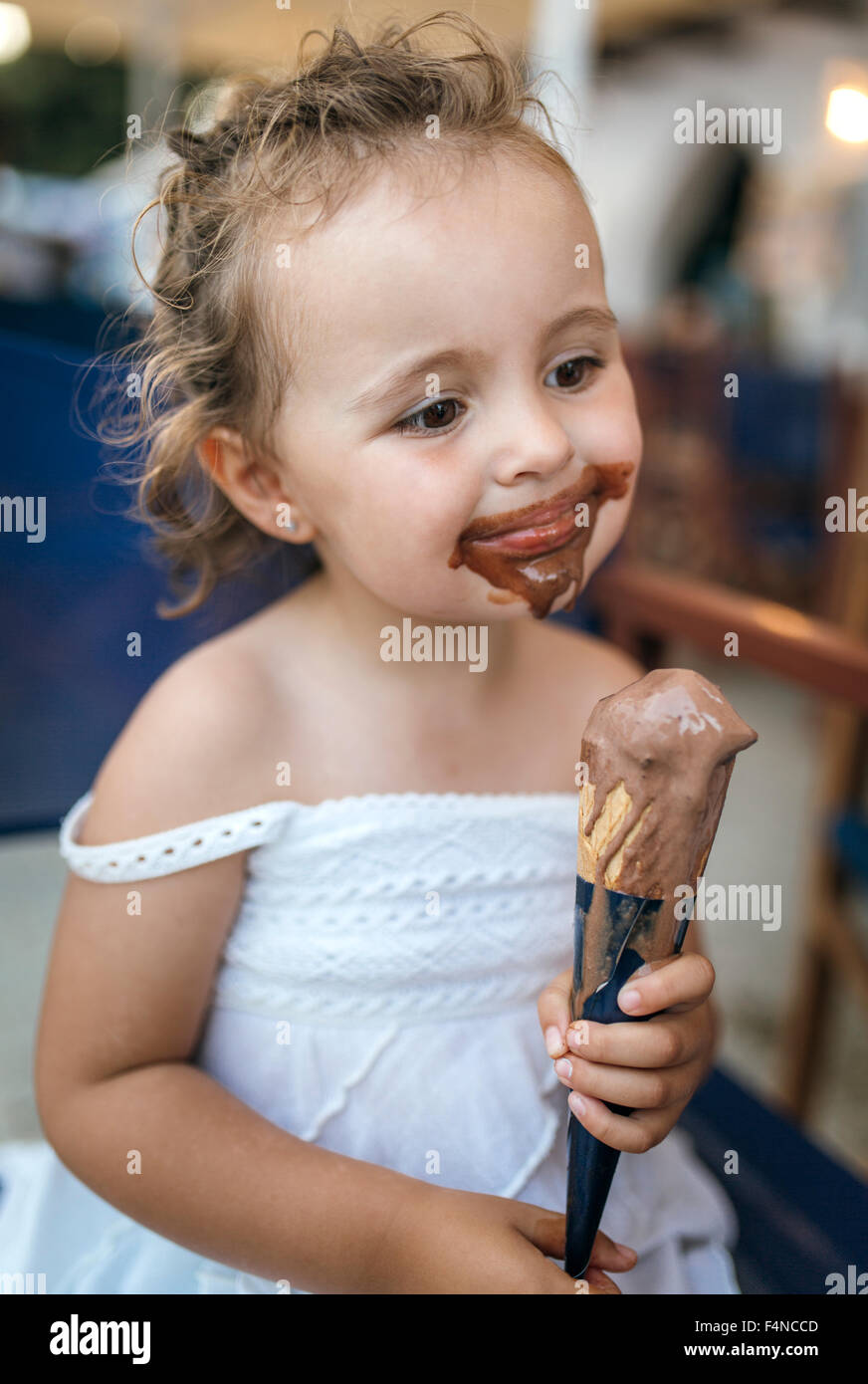 Portrait of smiling little girl with chocolate icecream around her ...