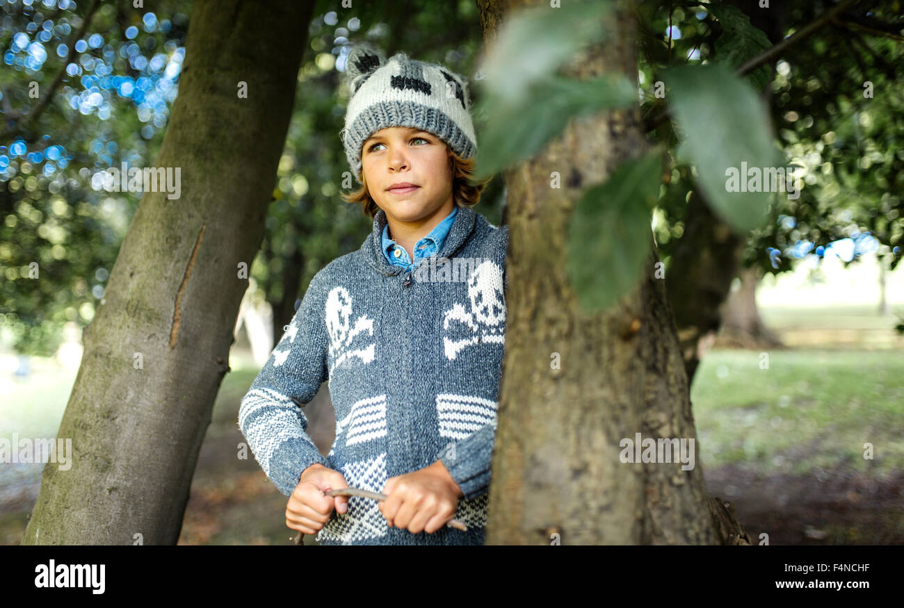Portrait of boy wearing autumn fashion standing between two trees Stock ...