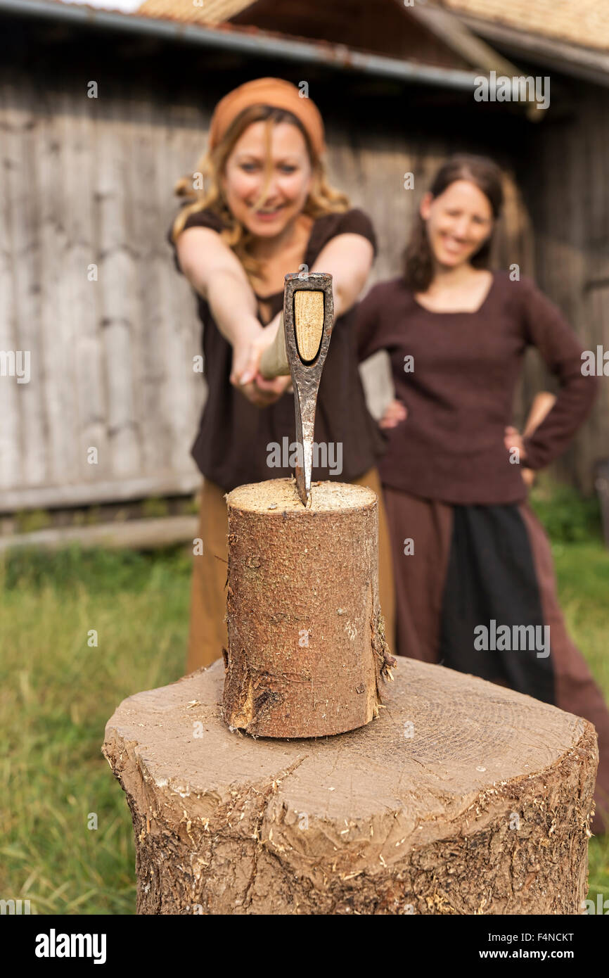 Two women chopping wood Stock Photo - Alamy