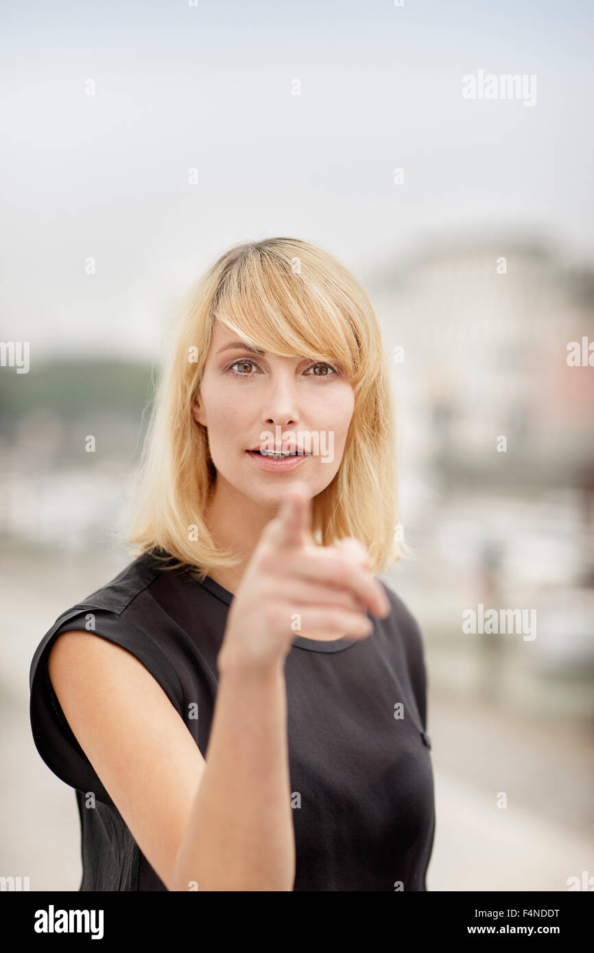 Portrait of blond woman pointing on viewer Stock Photo - Alamy
