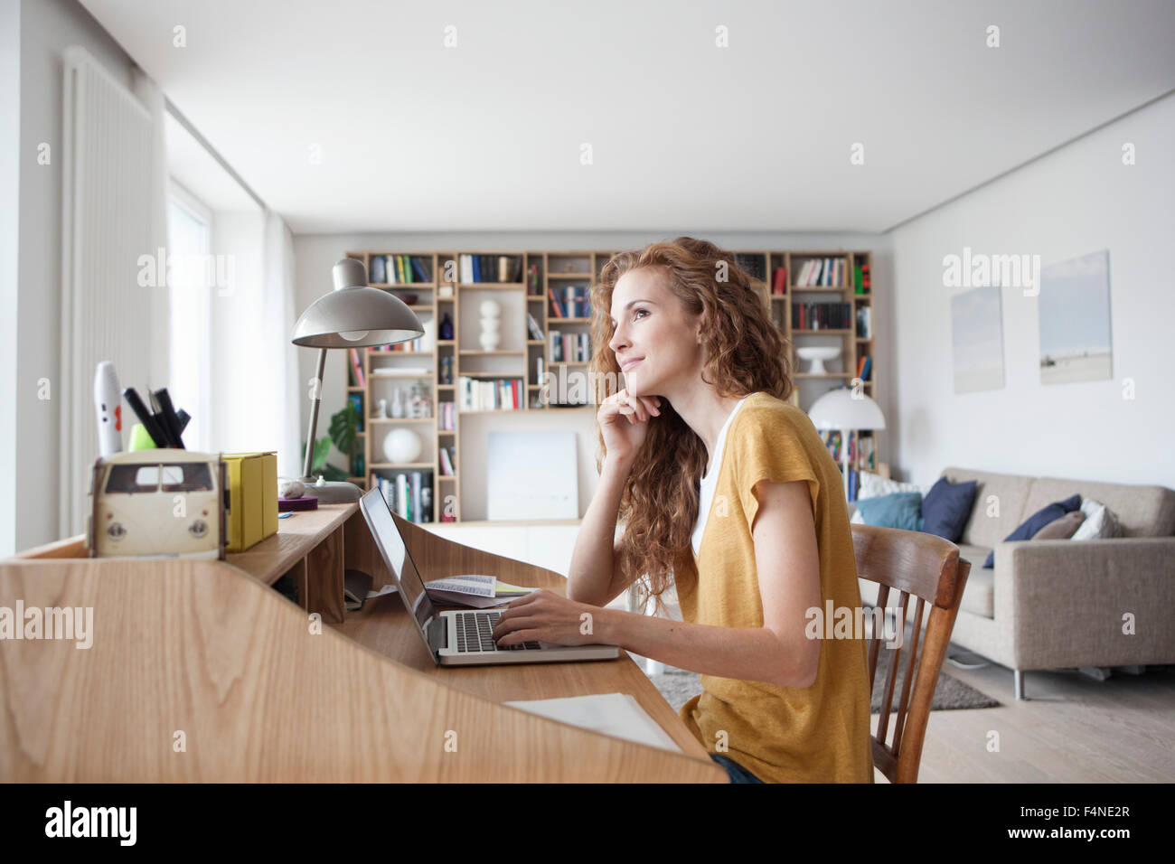 Woman at home using laptop on secretary desk Stock Photo - Alamy