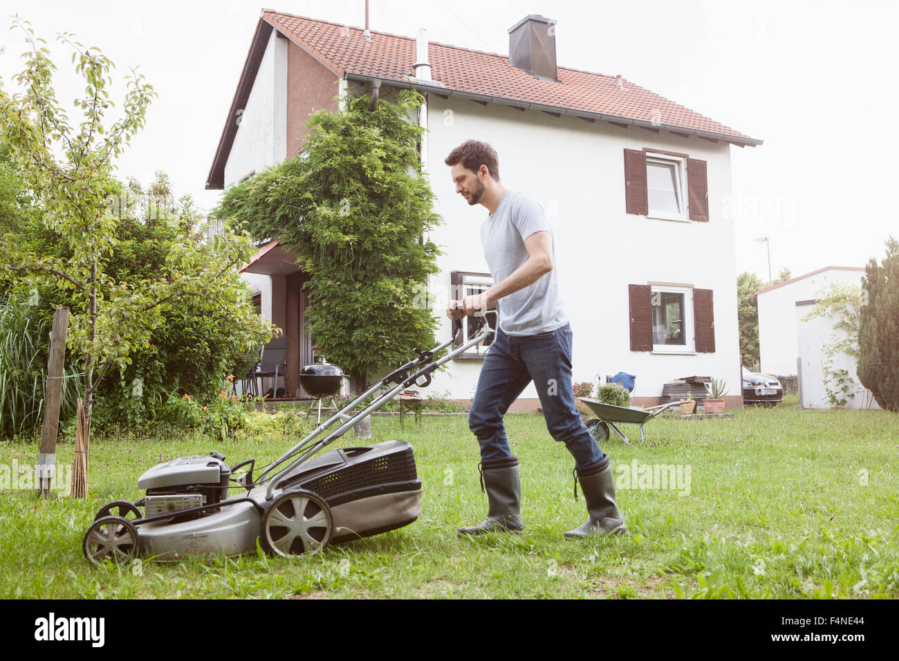 Man mowing the lawn Stock Photo - Alamy